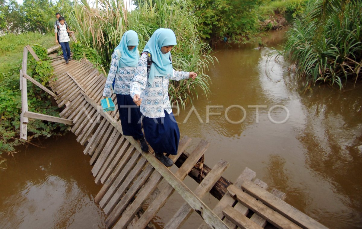 MELEWATI JEMBATAN RUSAK | ANTARA Foto