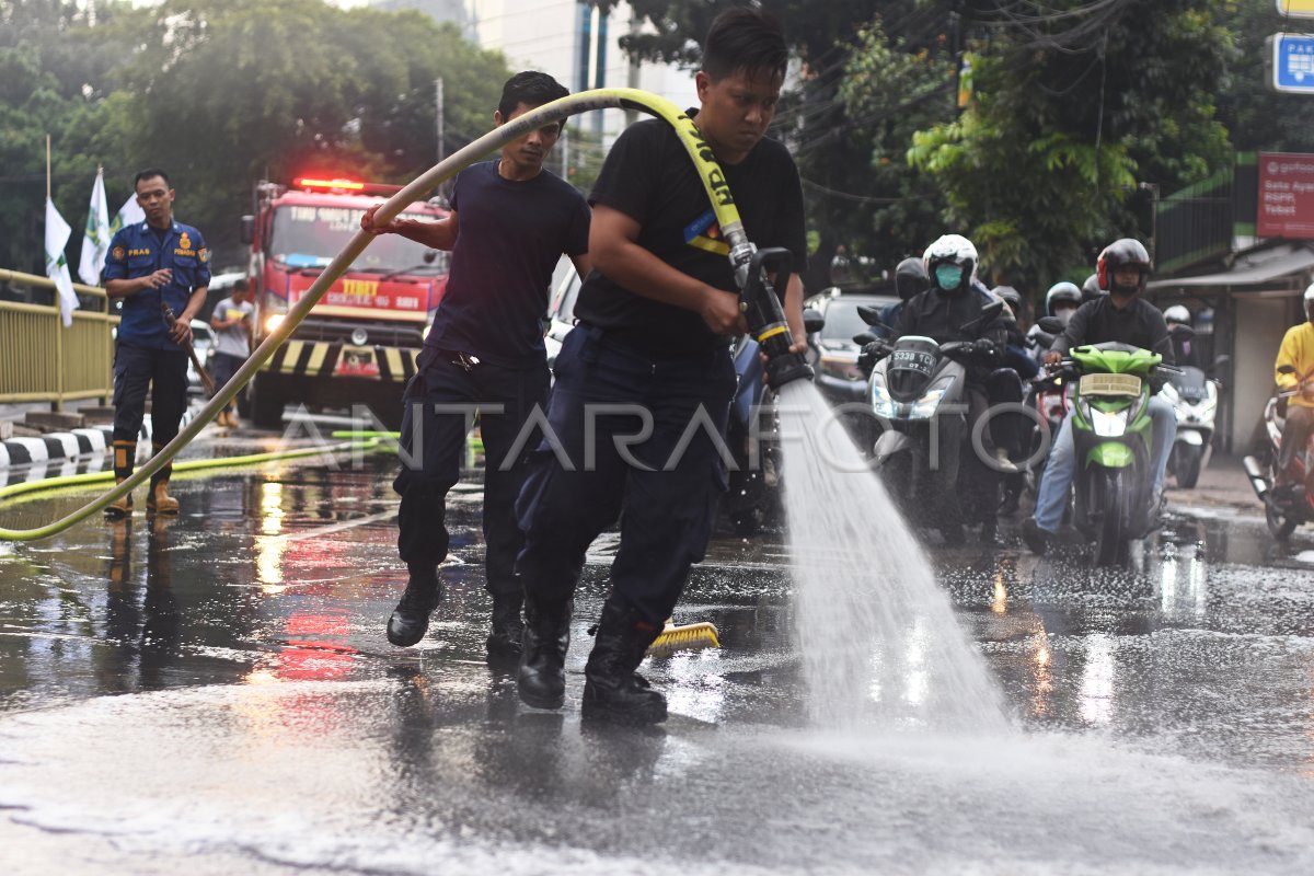 PETUGAS DAMKAR BERSIHKAN TUMPAHAN OLI DI JALAN | ANTARA Foto